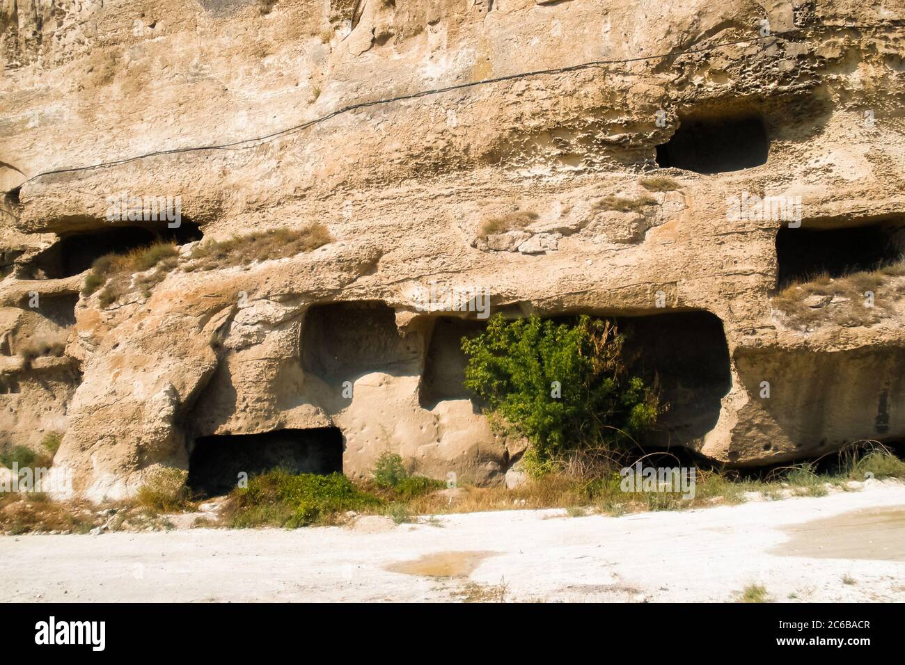 Ancient caves carved into the mountain wall hi-res stock photography ...