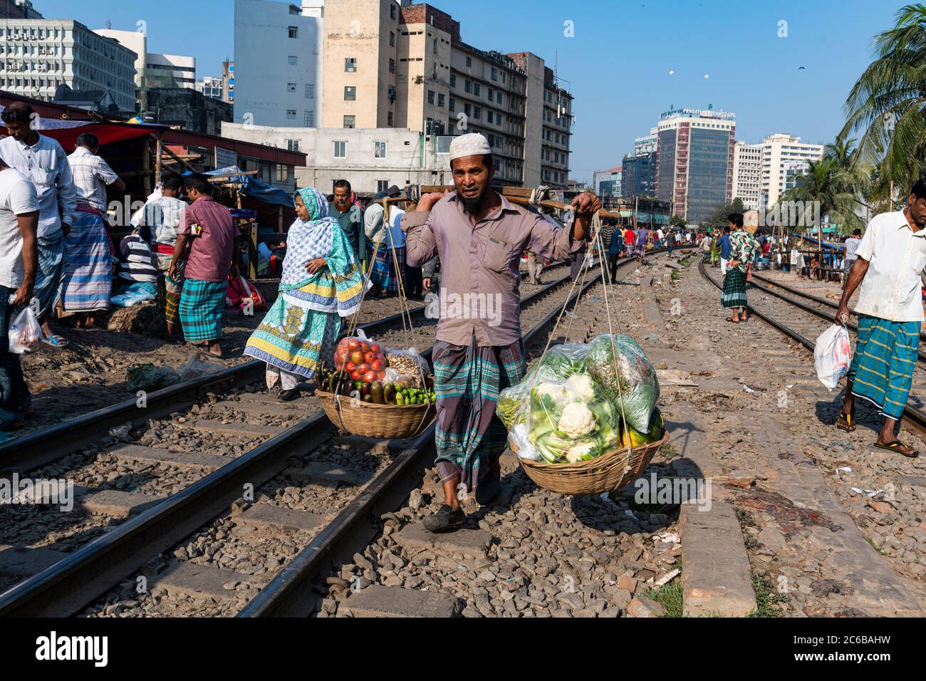 Street vendor on the railway tracks going through Kawran Bazaar, Dhaka ...