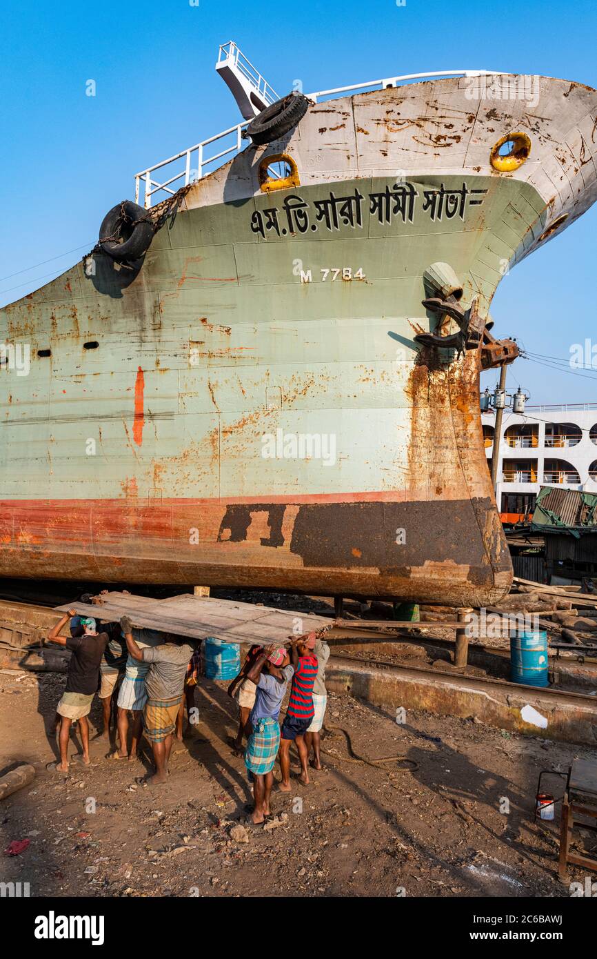 Men carrying a very heavy metal plate to the river, shipwreck cemetery ...
