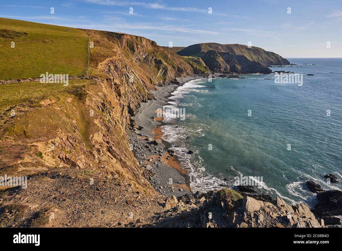 Cliffs along Devon's Atlantic coast bathed in late afternoon sunlight ...