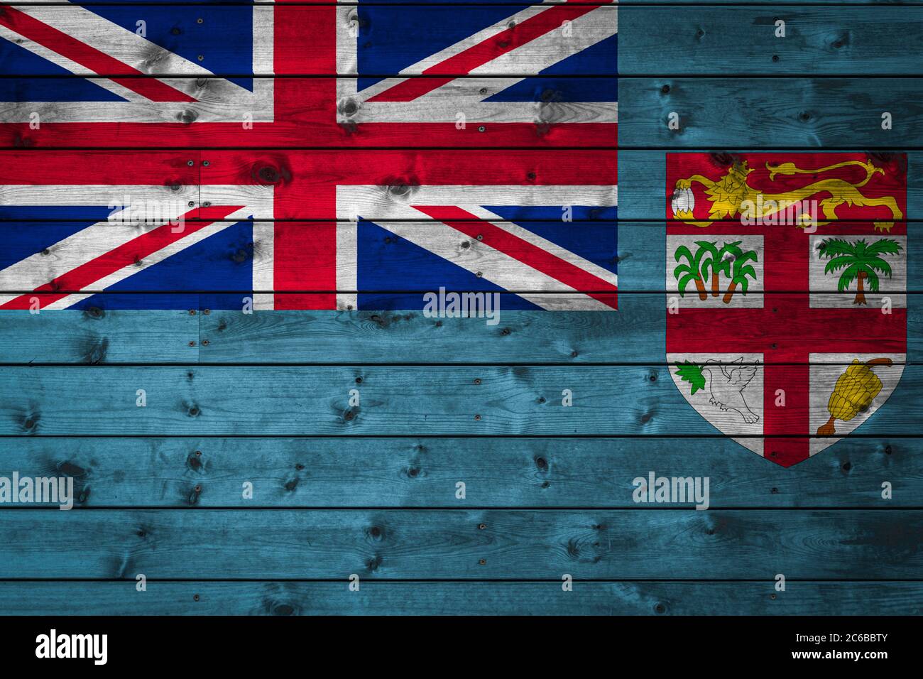 The national flag of Fiji is painted on a camp of even boards nailed ...