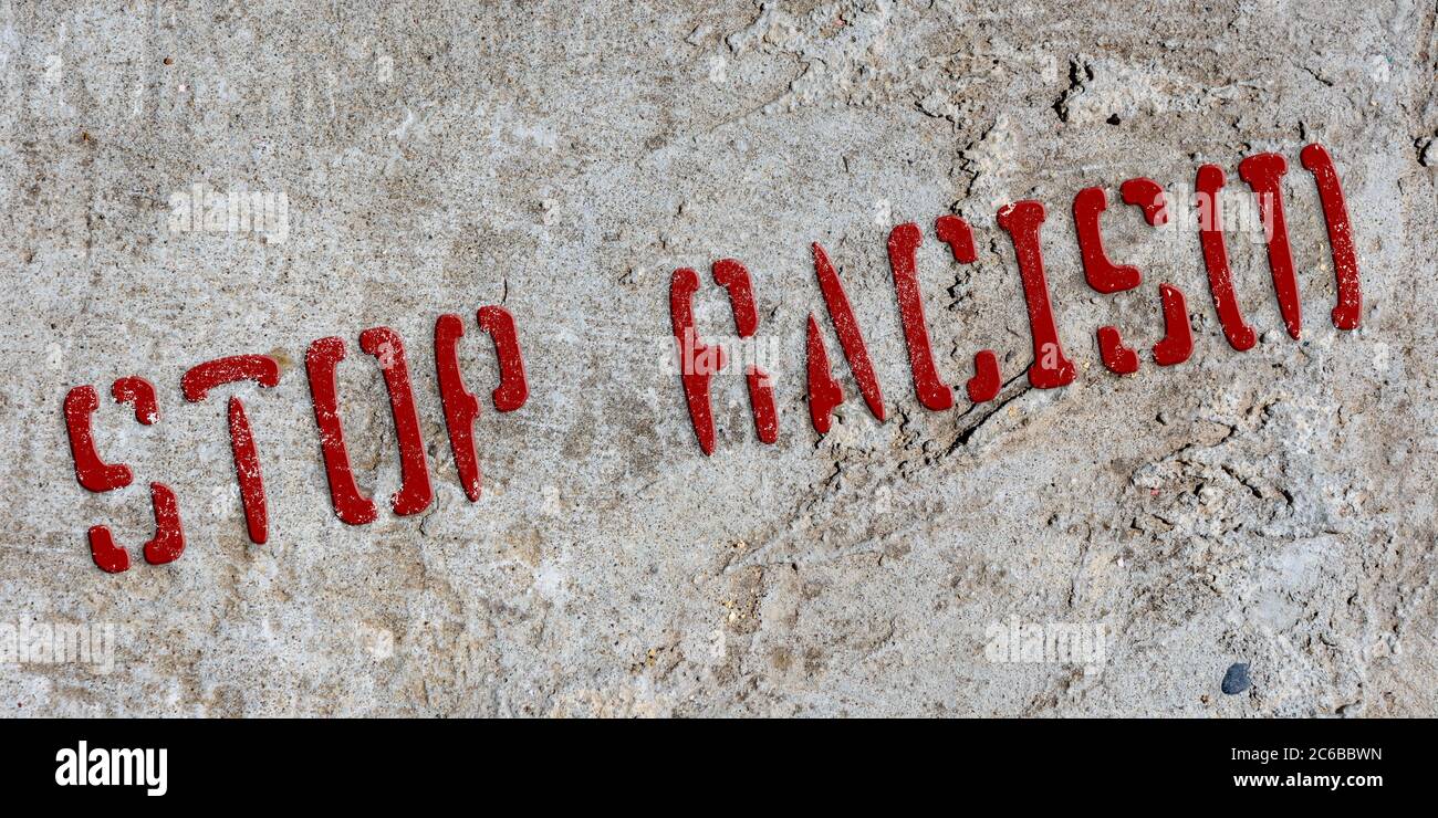 Stencil stop racism on an old concrete wall. Background. Collage ...