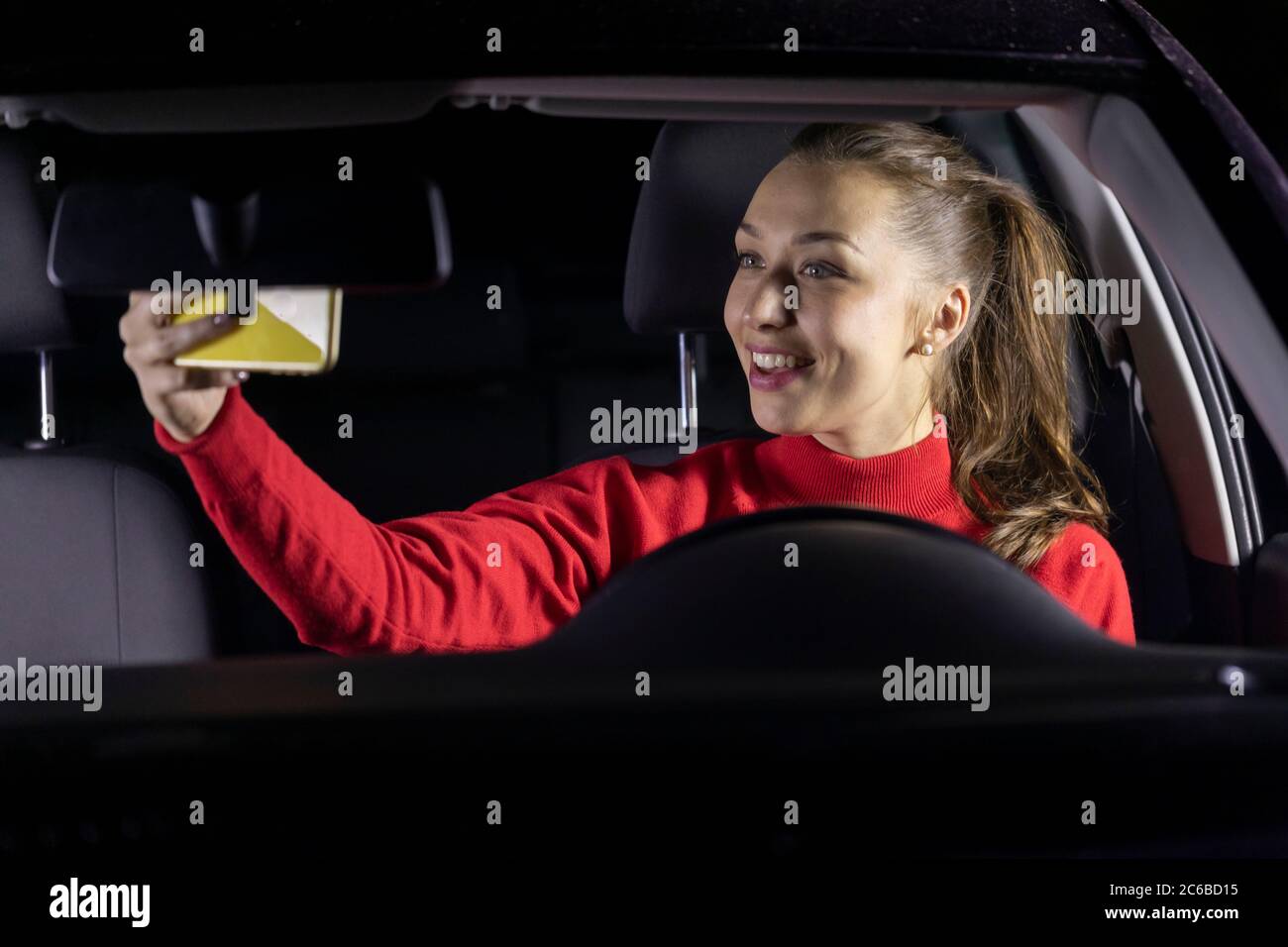Smiling female driver sitting inside car makes selfie, mobile ...