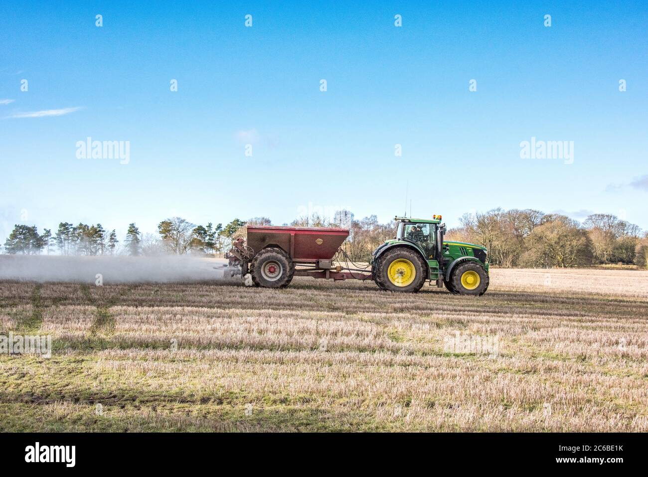 Rock dust and lime spreading on fields before cultivation. The ...