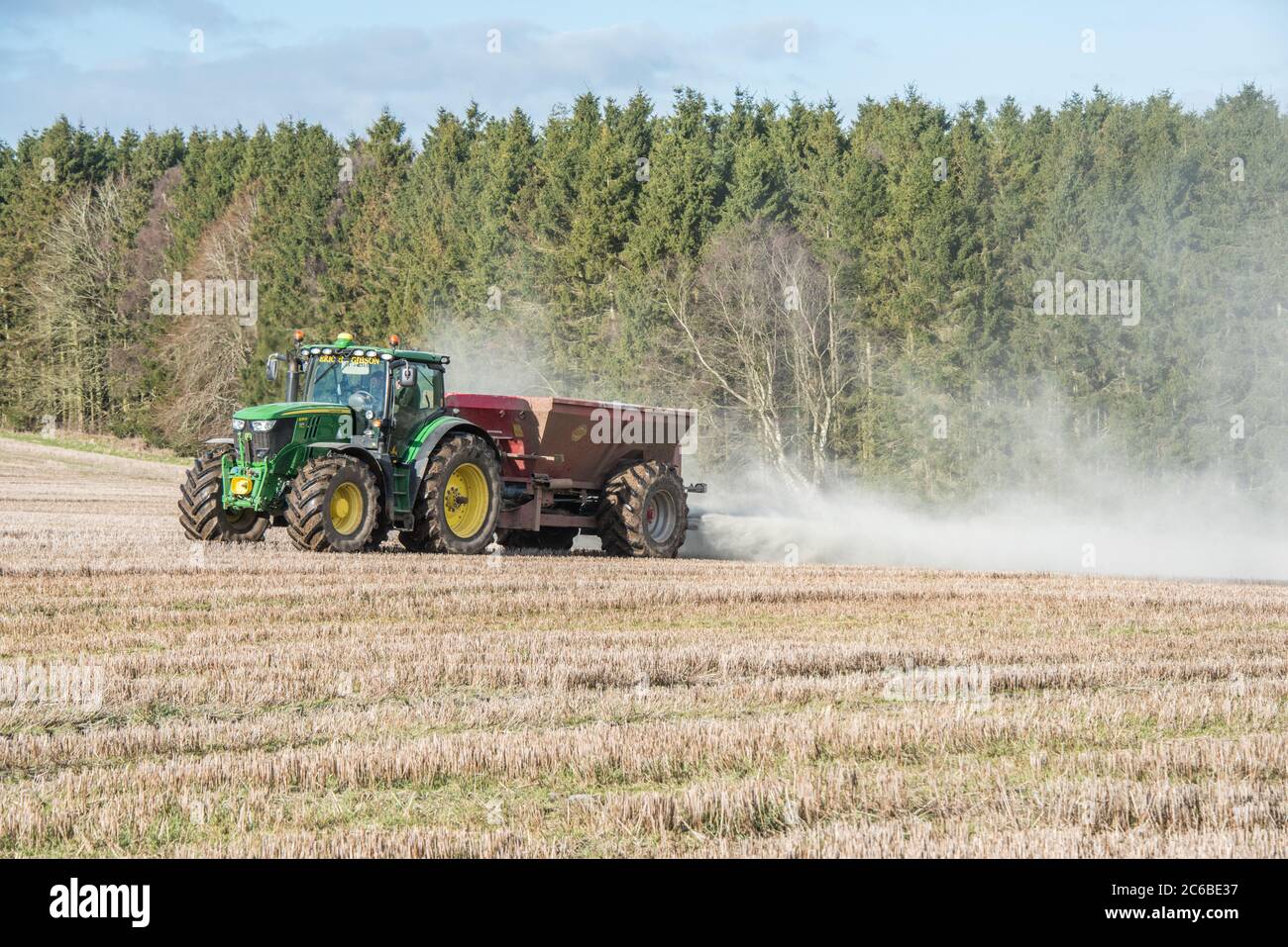 Rock dust and lime spreading on fields before cultivation. The ...
