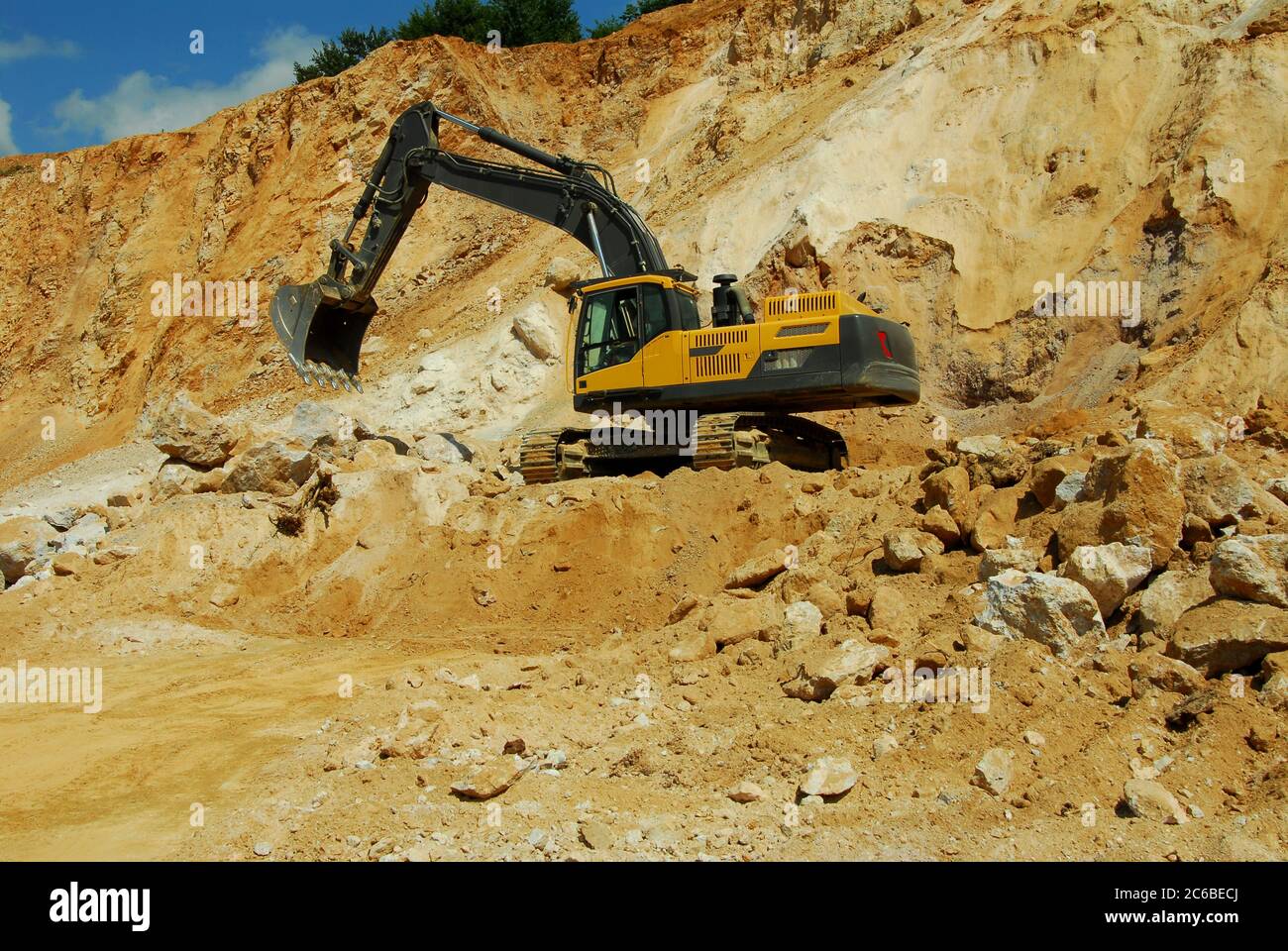 big yellow loader carries a large stone in the quarry Stock Photo - Alamy