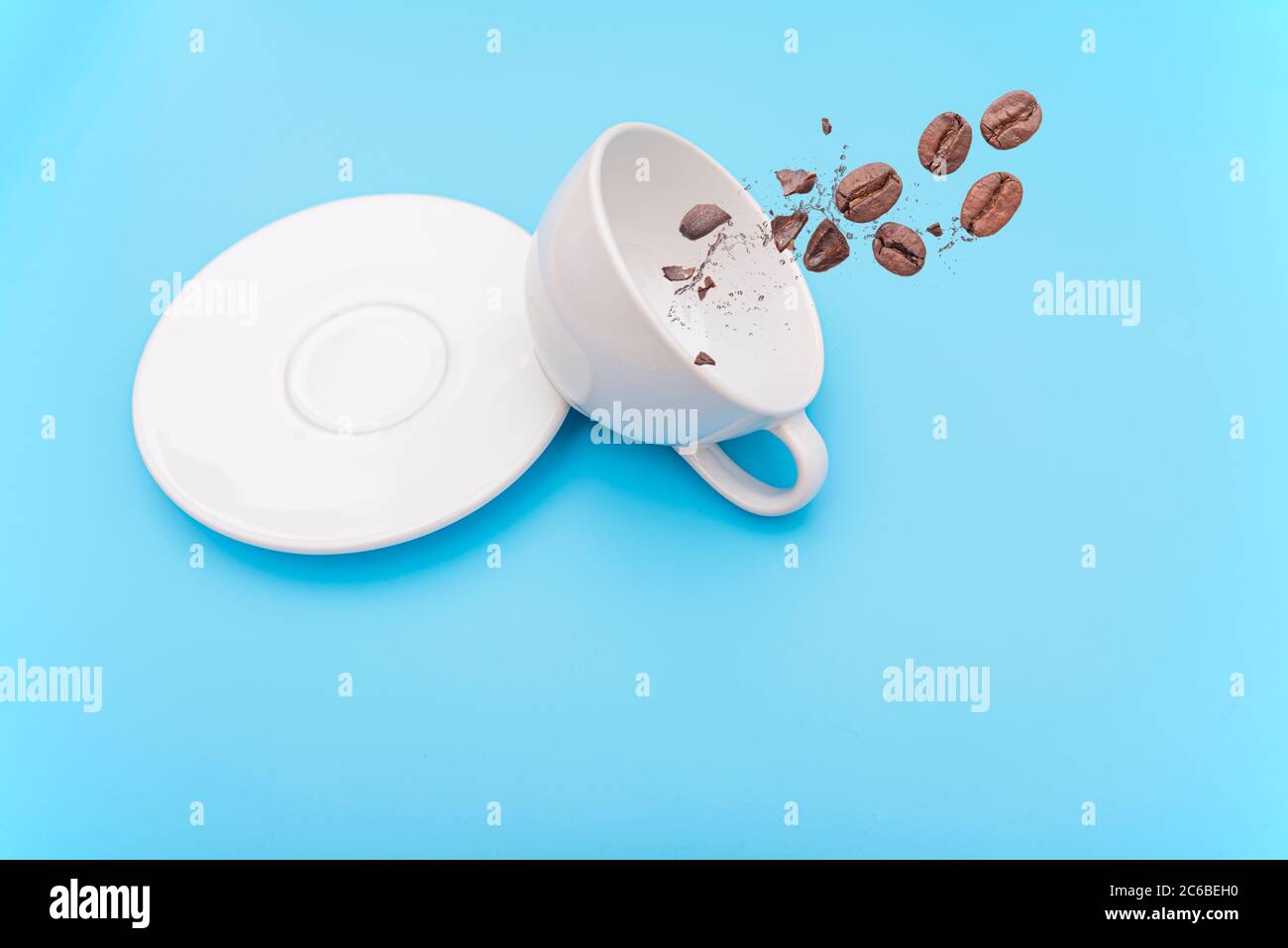 Overturned or knocked over white coffee cup, mug with bowl and coffee ...