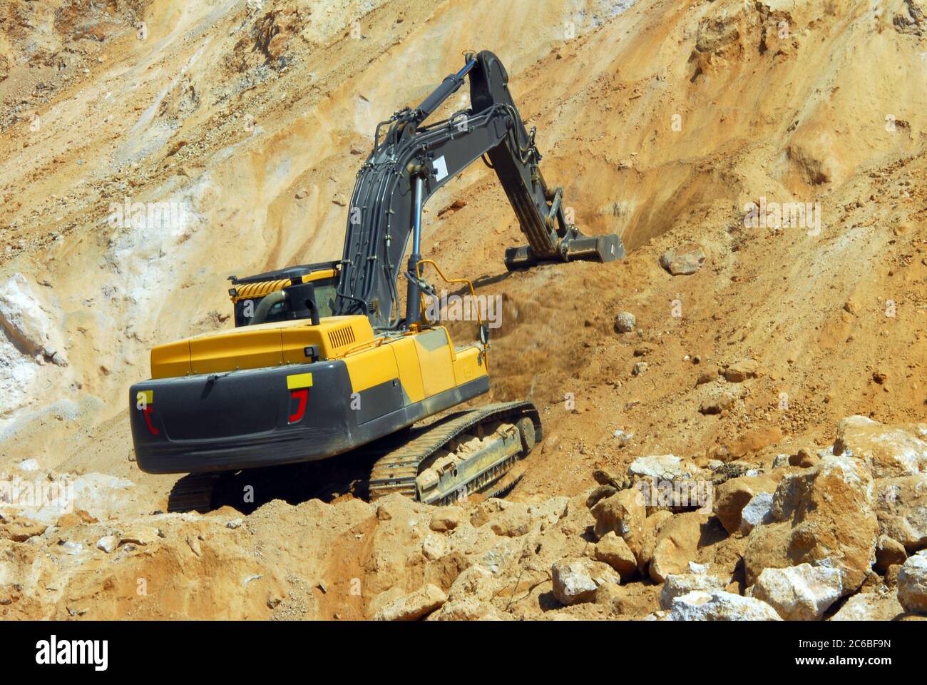 Yellow loader, dredge, big yellow loader carries a large stone in the ...