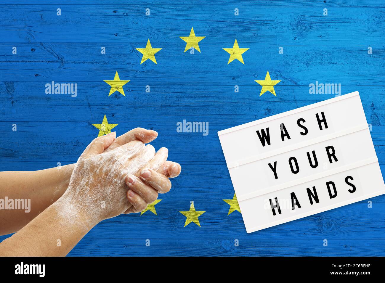 European Union flag background on wooden surface. Minimal wash your ...