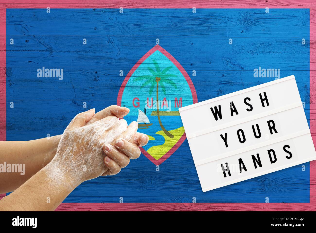 Guam flag background on wooden surface. Minimal wash your hands board ...