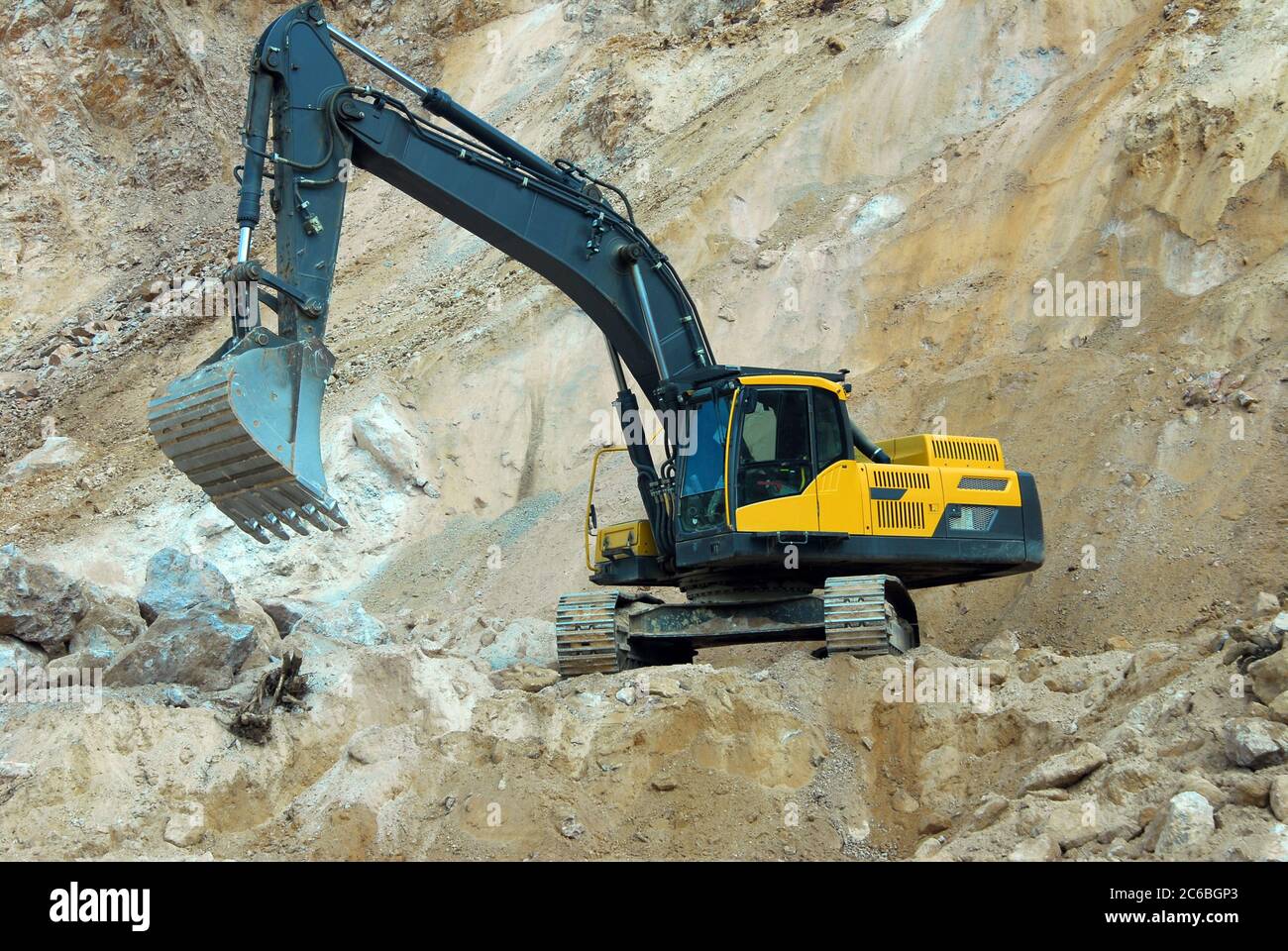 Yellow loader, dredge, big yellow loader carries a large stone in the ...