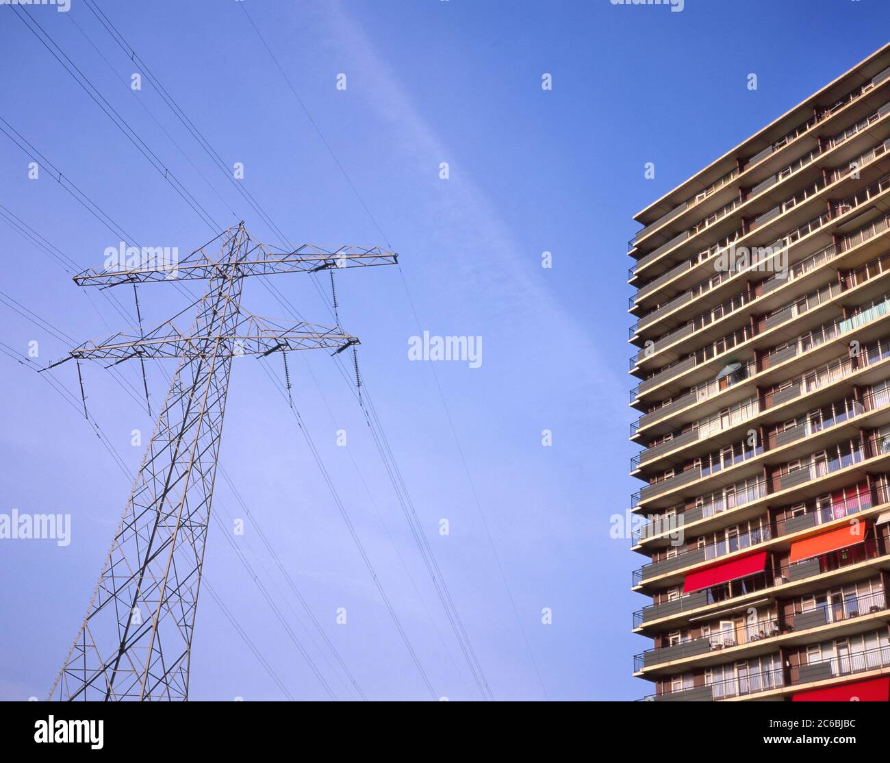 Apartment building next to a high voltage electricity pole Stock Photo ...