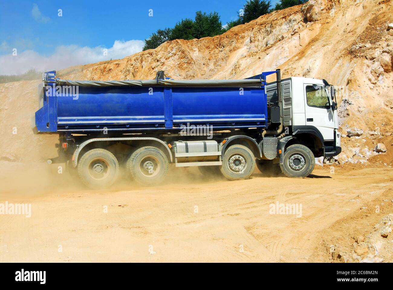 Big truck in a quarry, Large dump truck driving in the dust in the ...
