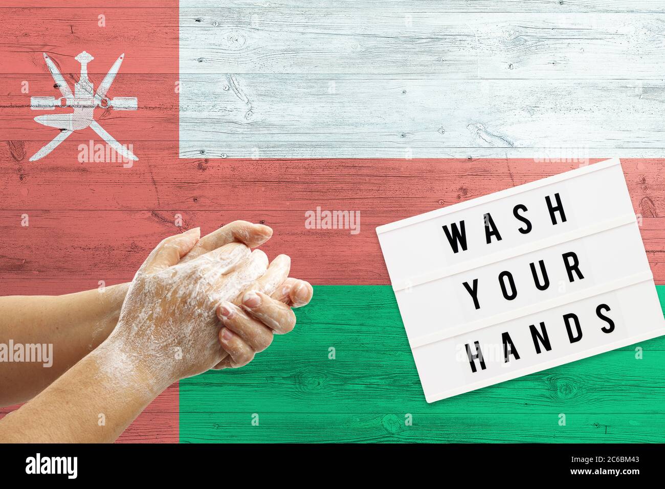 Oman flag background on wooden surface. Minimal wash your hands board ...