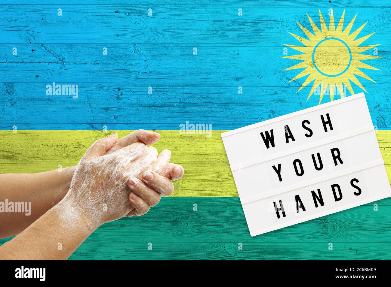 Rwanda flag background on wooden surface. Minimal wash your hands board ...