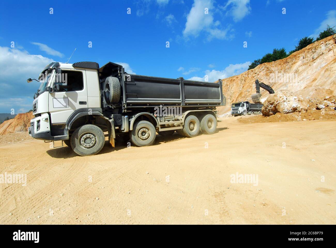 big truck in a quarry, large dump truck driving in the dust in the ...