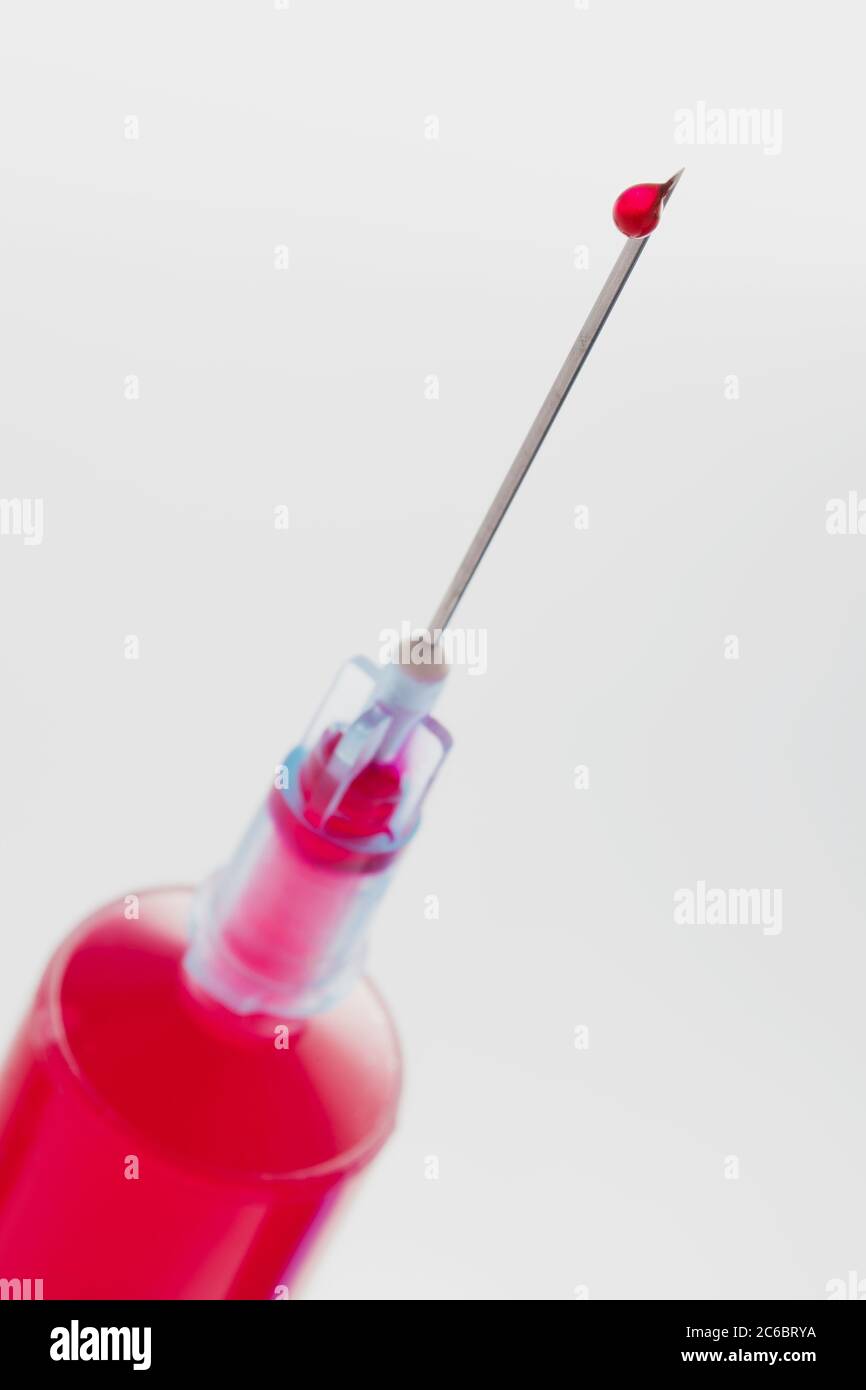 Vertical image of Syringe with a drop of blood at the tip of it's ...