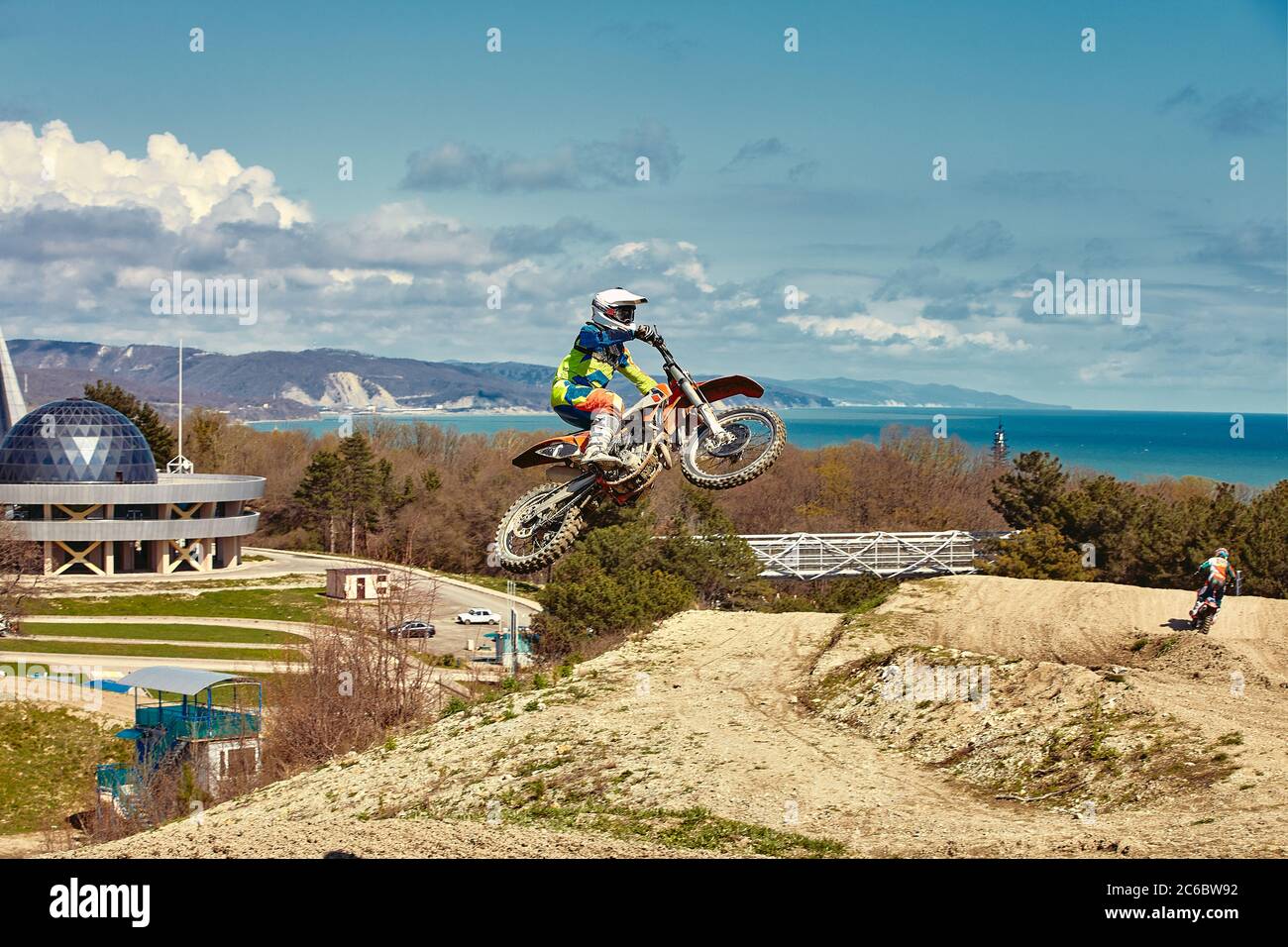 Motocross driver in action accelerating the motorbike takes off and ...