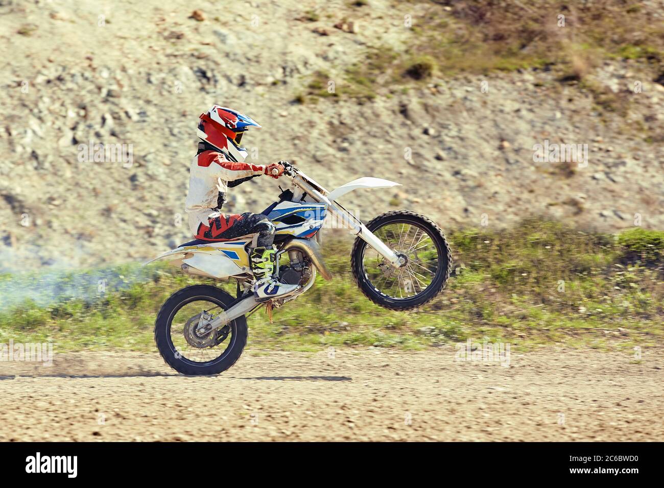 Motocross driver in action accelerating the motorbike takes off and ...