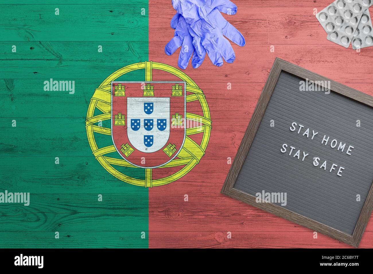 Portugal flag background on wooden table. Stay Home writing board ...