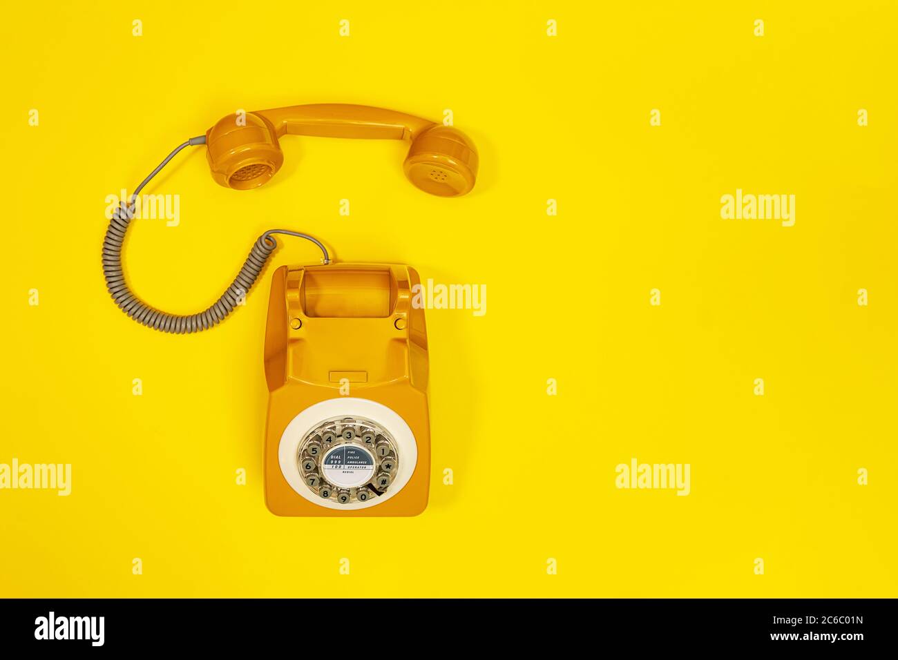 Yellow handset of a telephone on a yellow background. Modern retro ...