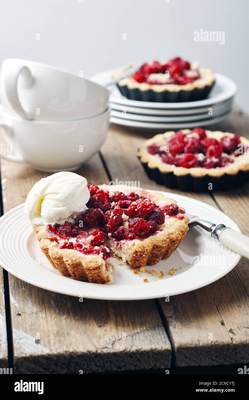 Baked mini pies with raspberries on a rustic wooden table Stock Photo ...
