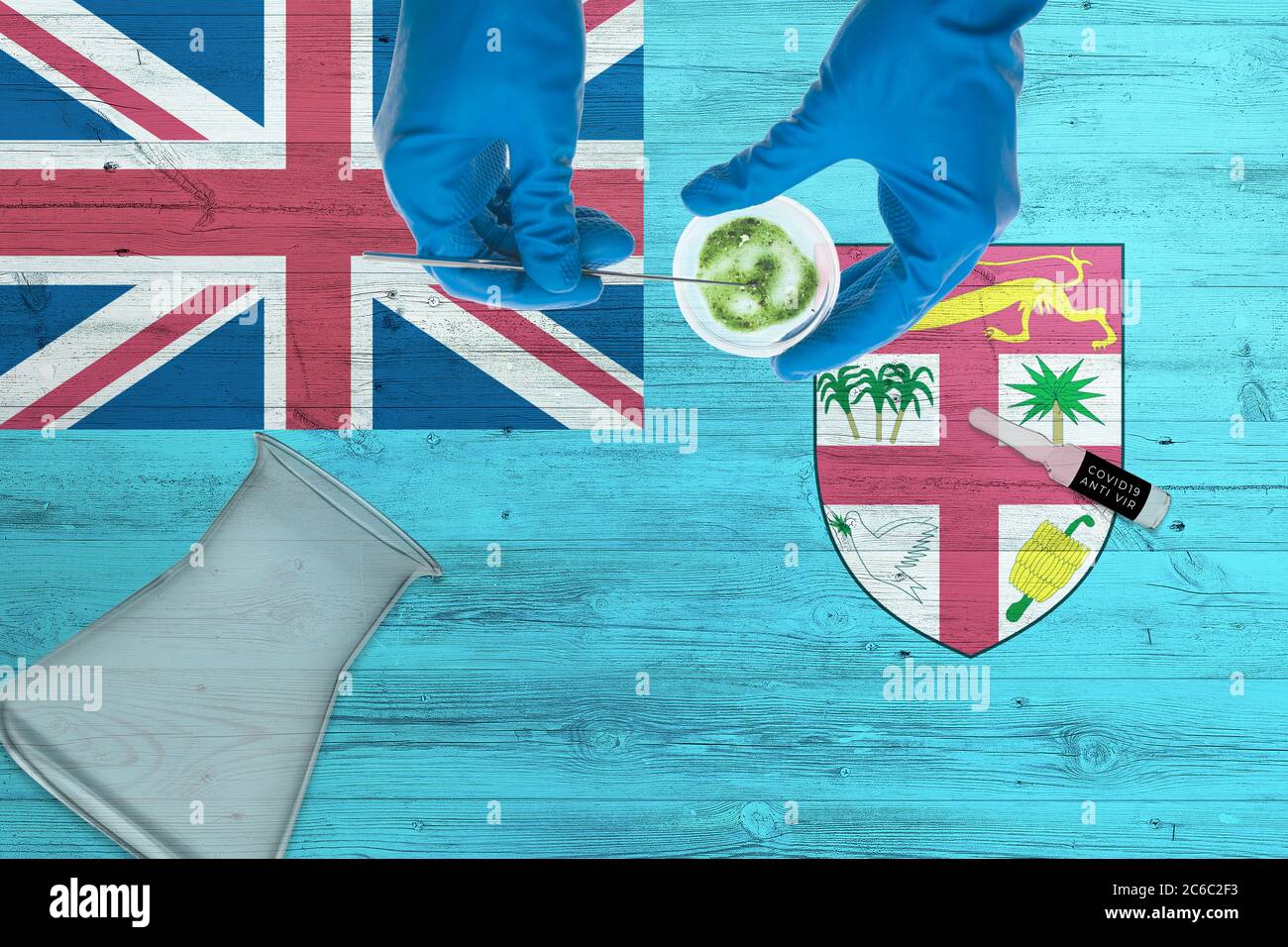 Fiji flag on laboratory table. Medical healthcare technologist holding ...