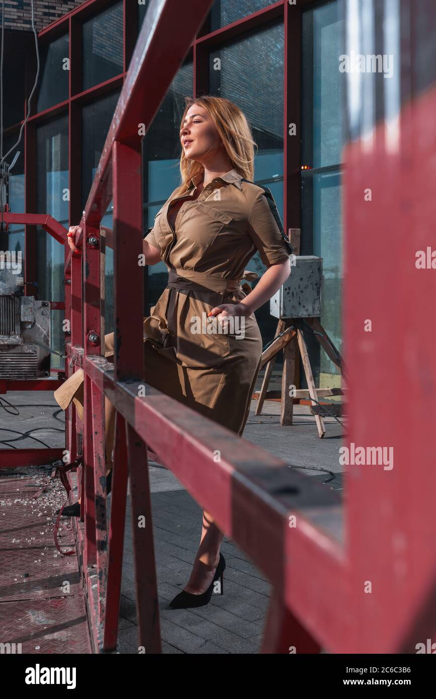 Beautiful Blonde Woman In Stylish Dress At Construction Site Near ...