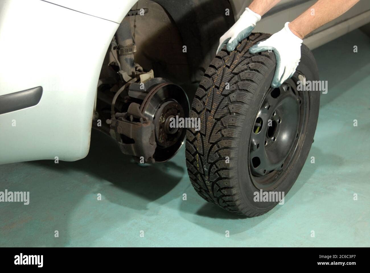 Man changing car tires. Car mechanic in a workshop changing tire Stock ...