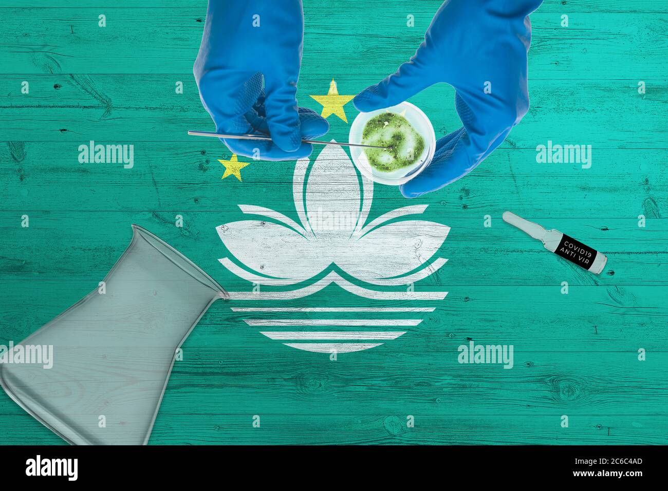 Macao flag on laboratory table. Medical healthcare technologist holding ...