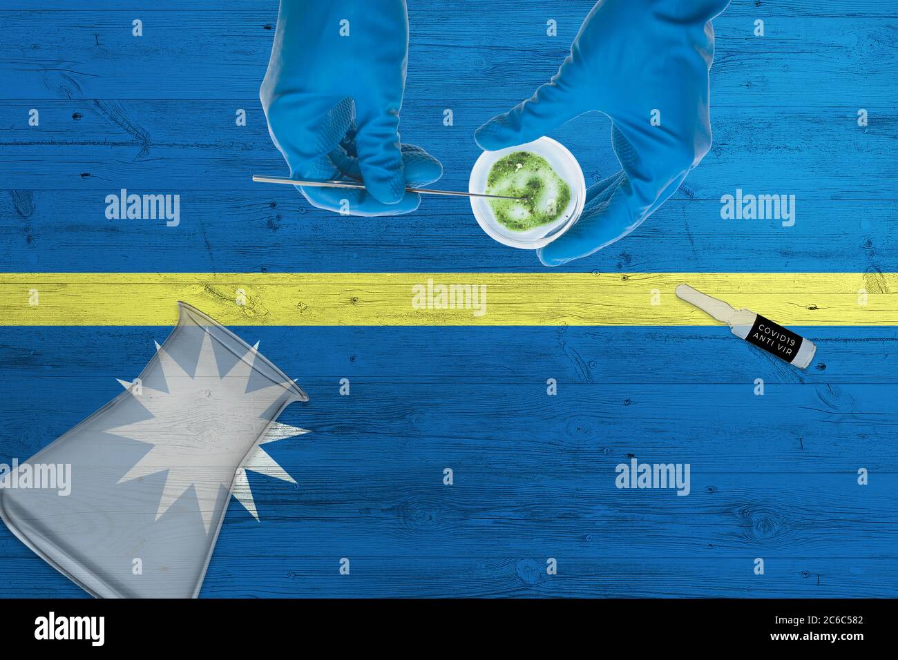 Nauru flag on laboratory table. Medical healthcare technologist holding ...