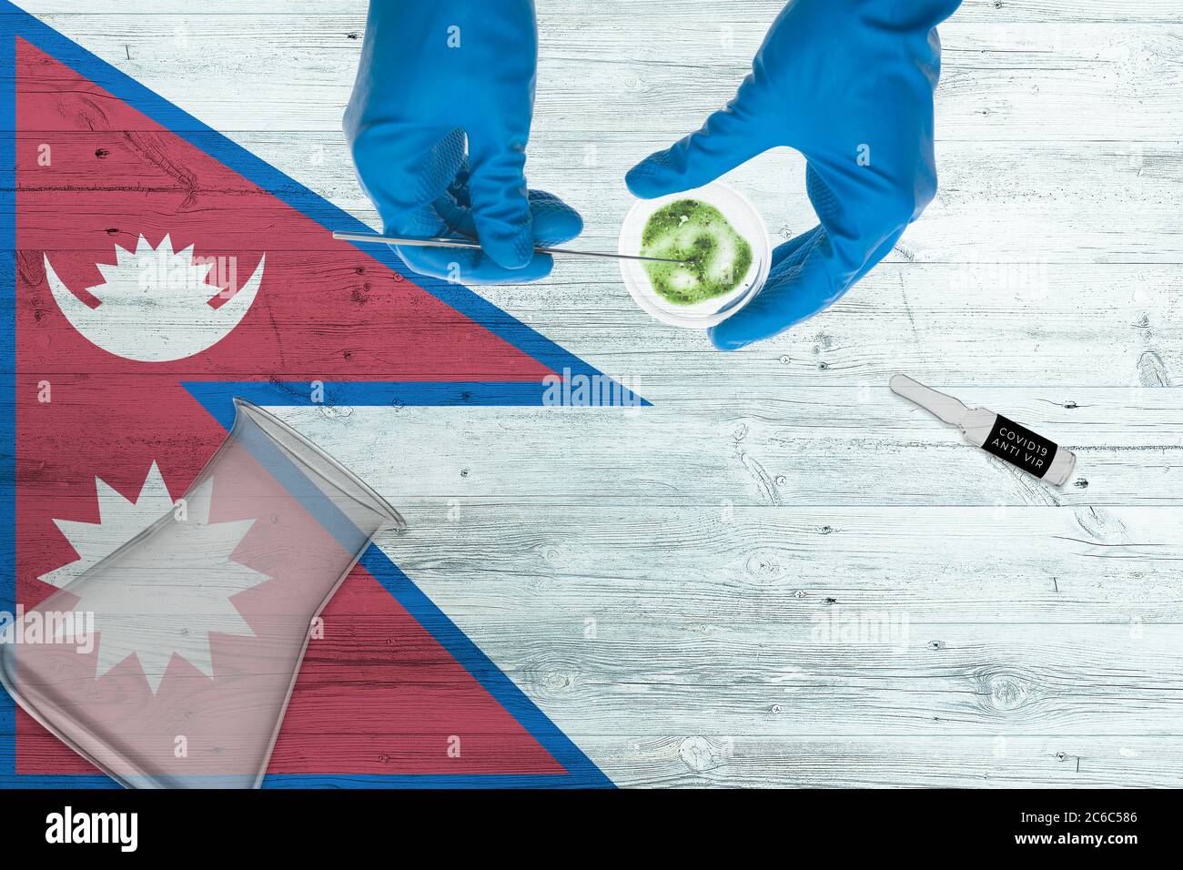 Nepal flag on laboratory table. Medical healthcare technologist holding ...