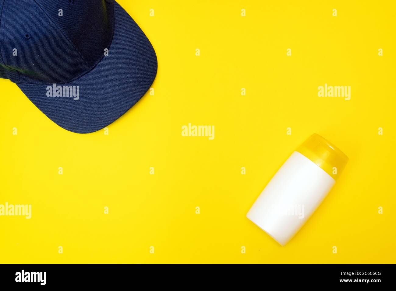A suncream and cap are on the yellow background. Sun protection ...