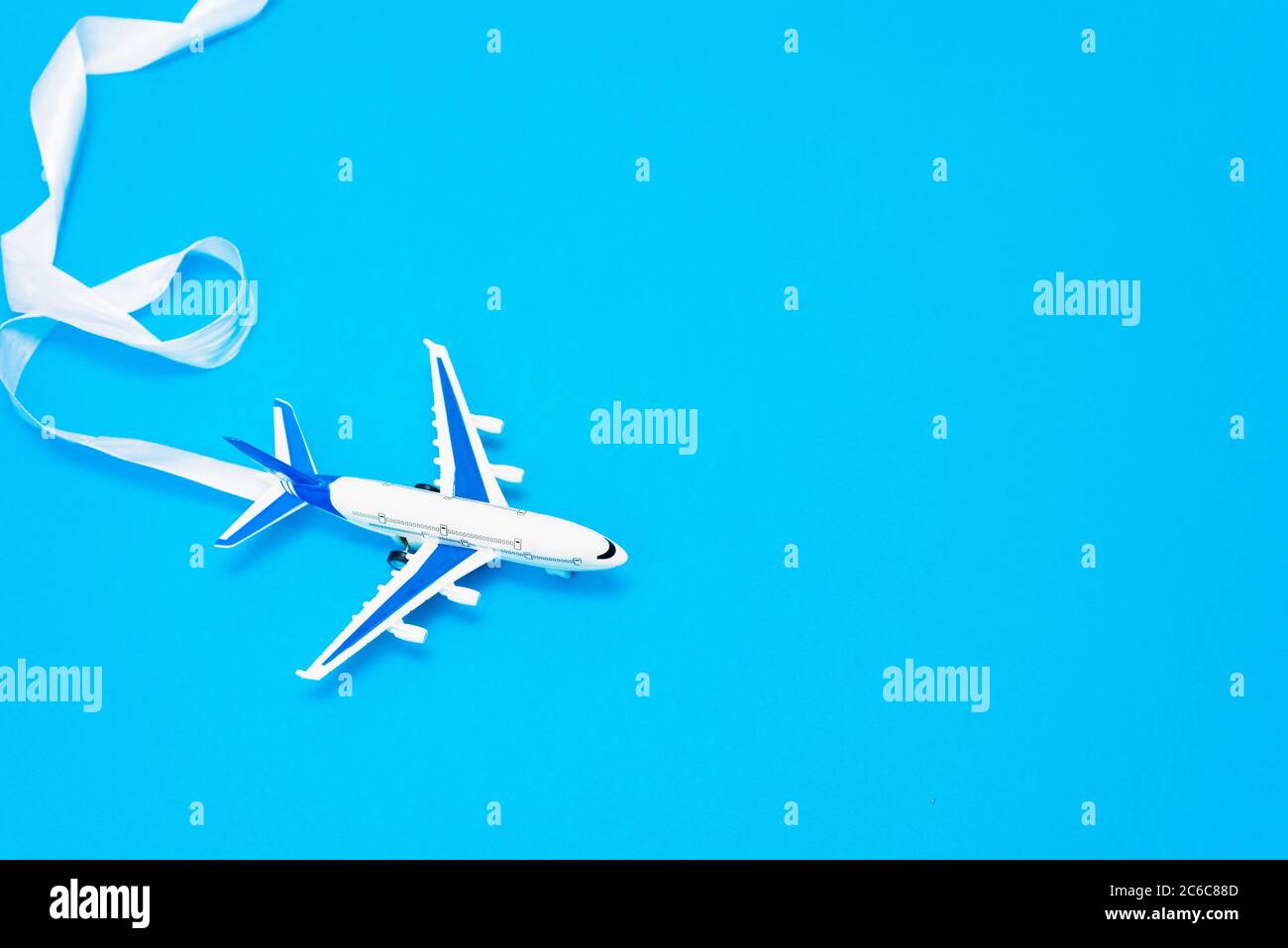 Flat lay design of travel concept with plane on blue background with ...