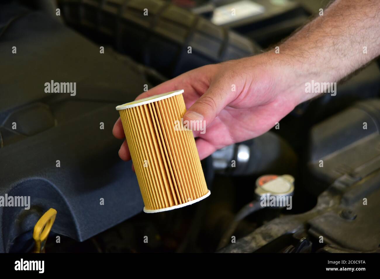 Replacement of car oil filter. Repairman holding an new car oil filter ...
