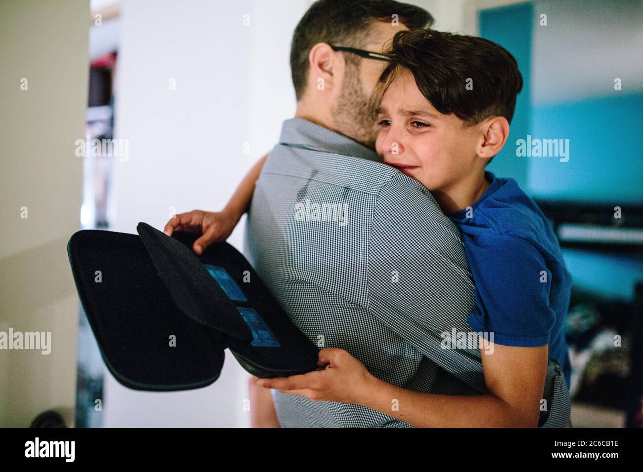 Father holds son who is crying while tears streak dad's shirt Stock ...