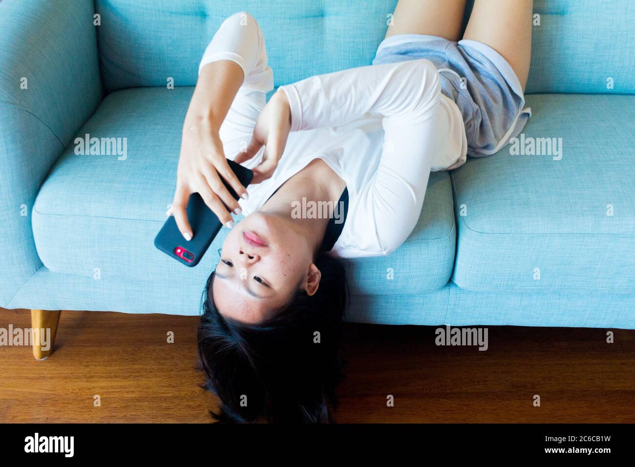 Asian teenage girl lay down using mobile phone Stock Photo - Alamy