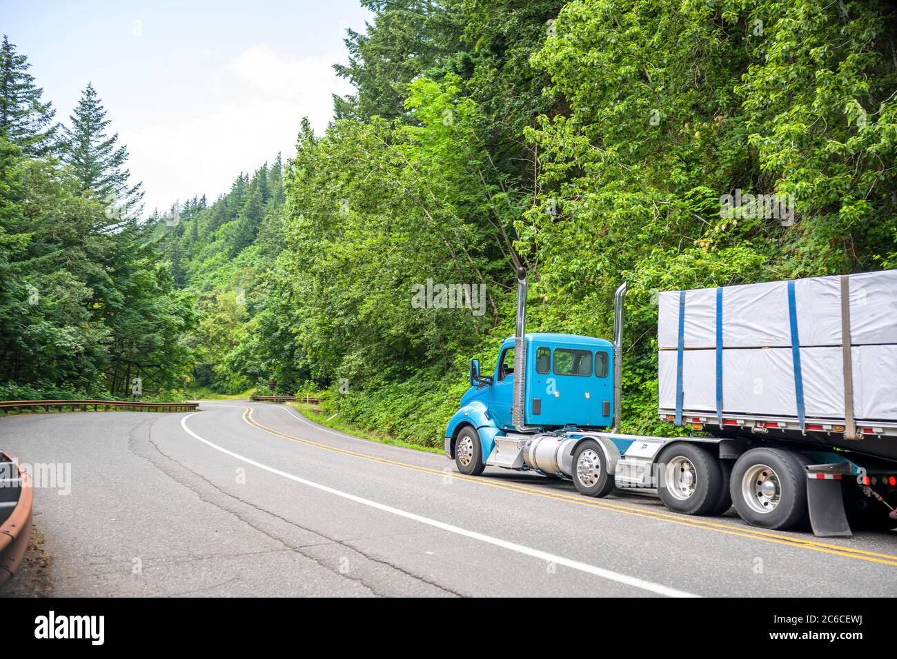 Big rig blue day cab semi truck with vertical exhaust pipes ...