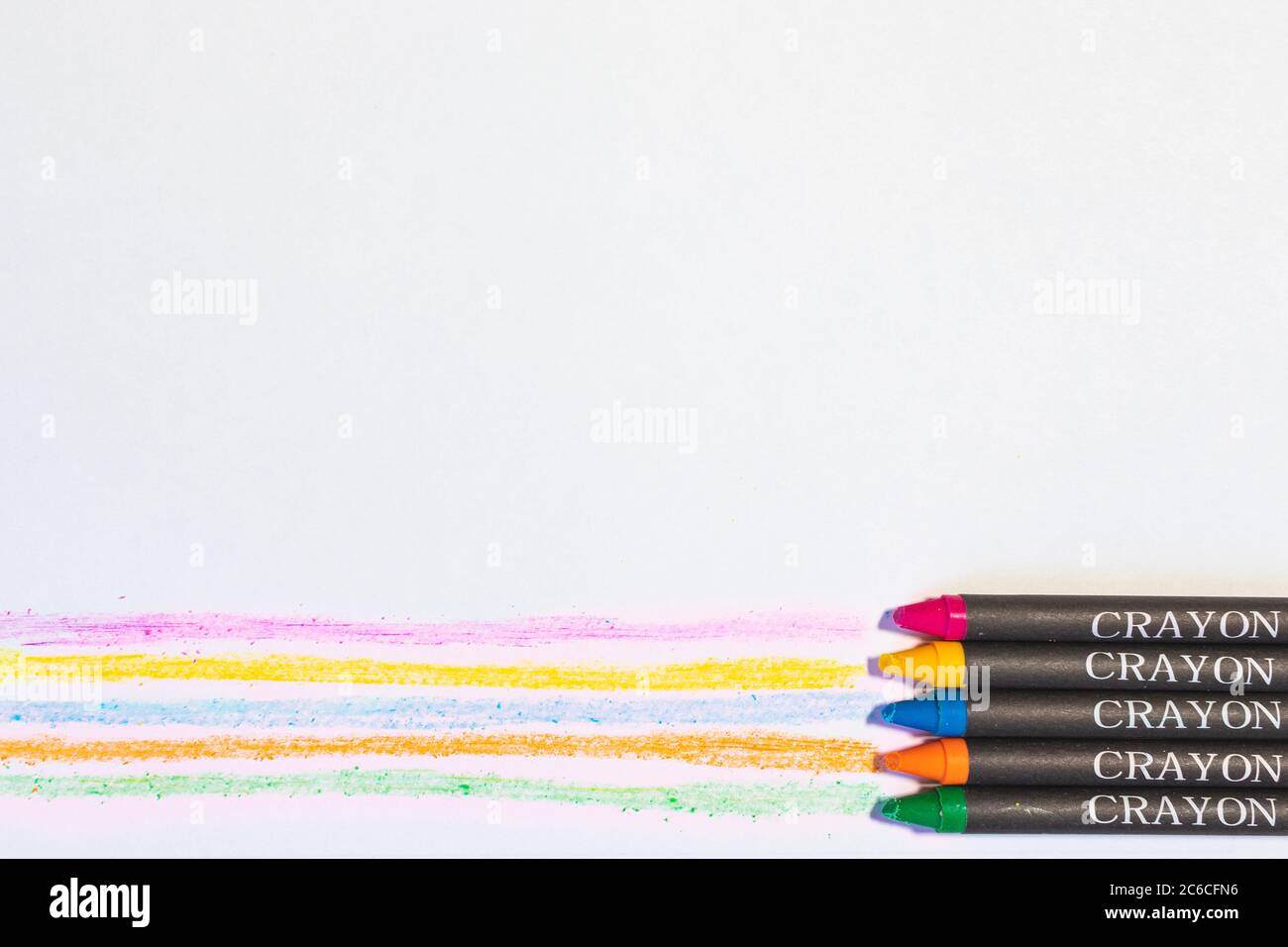 colorful crayons aligned making colorful lines on a white background ...