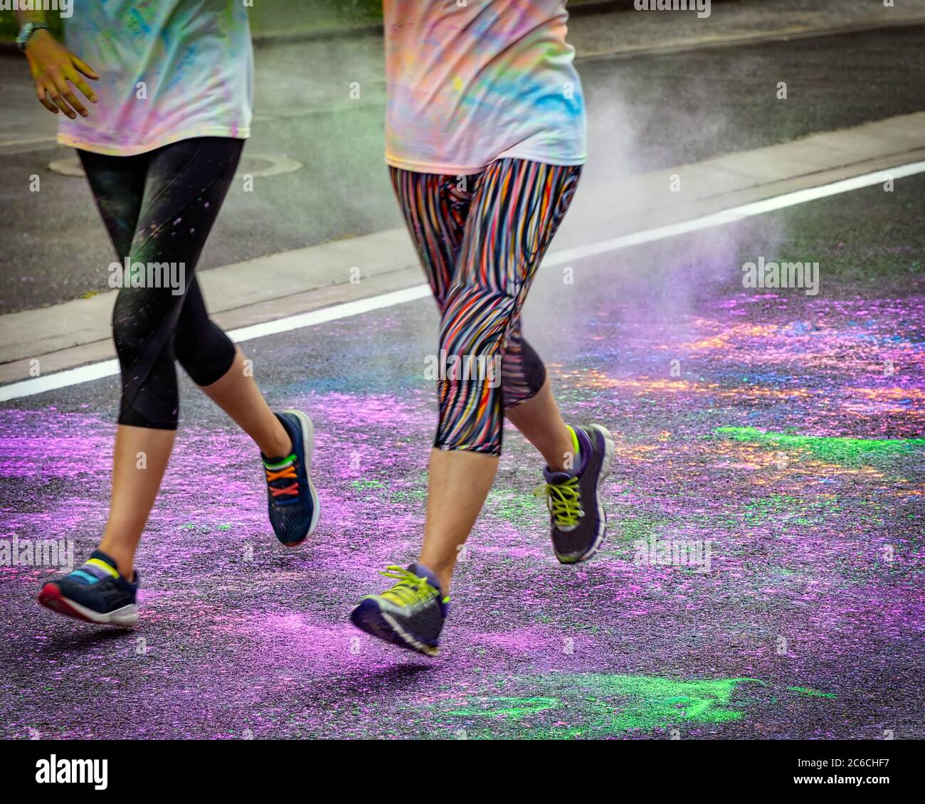 Two runners crossing the finish line at a color run Stock Photo - Alamy