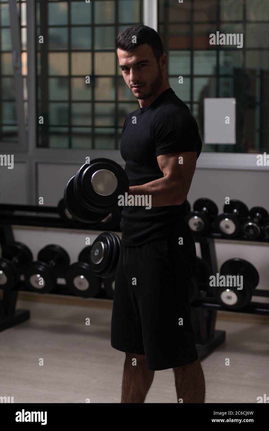 Athlete Working Out Biceps In A Gym - Dumbbell Concentration Curls ...