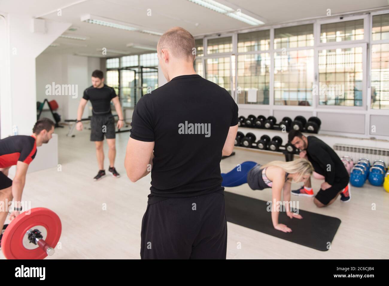 Group of People Exercising Together Lifting Weight Using Skipping Rope ...