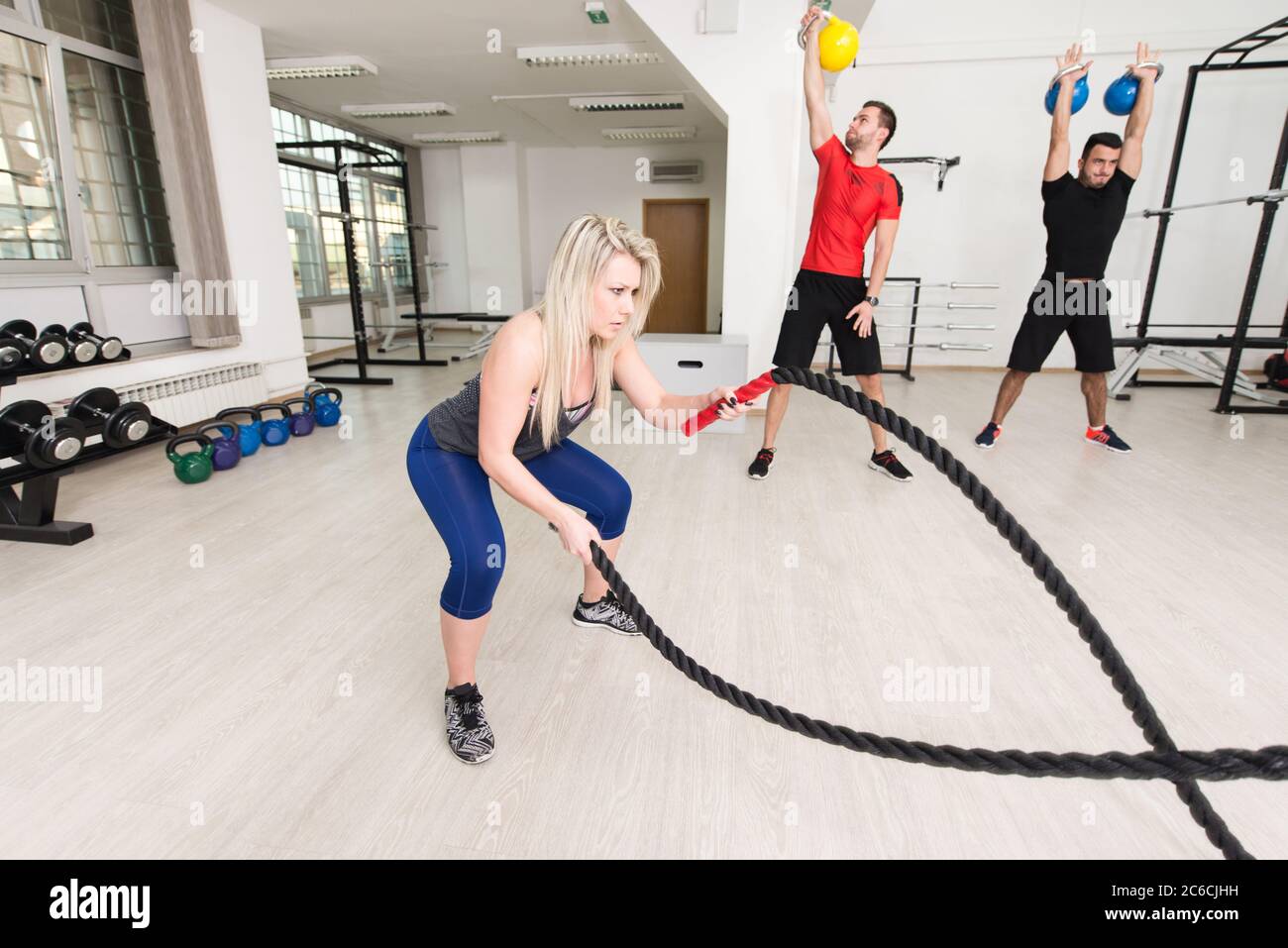 Group of People Exercising Together Lifting Weight Using Skipping Rope ...
