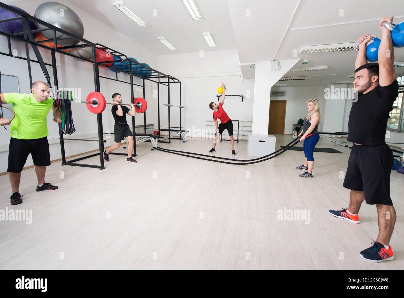 Group of People Exercising Together Lifting Weight Using Skipping Rope ...
