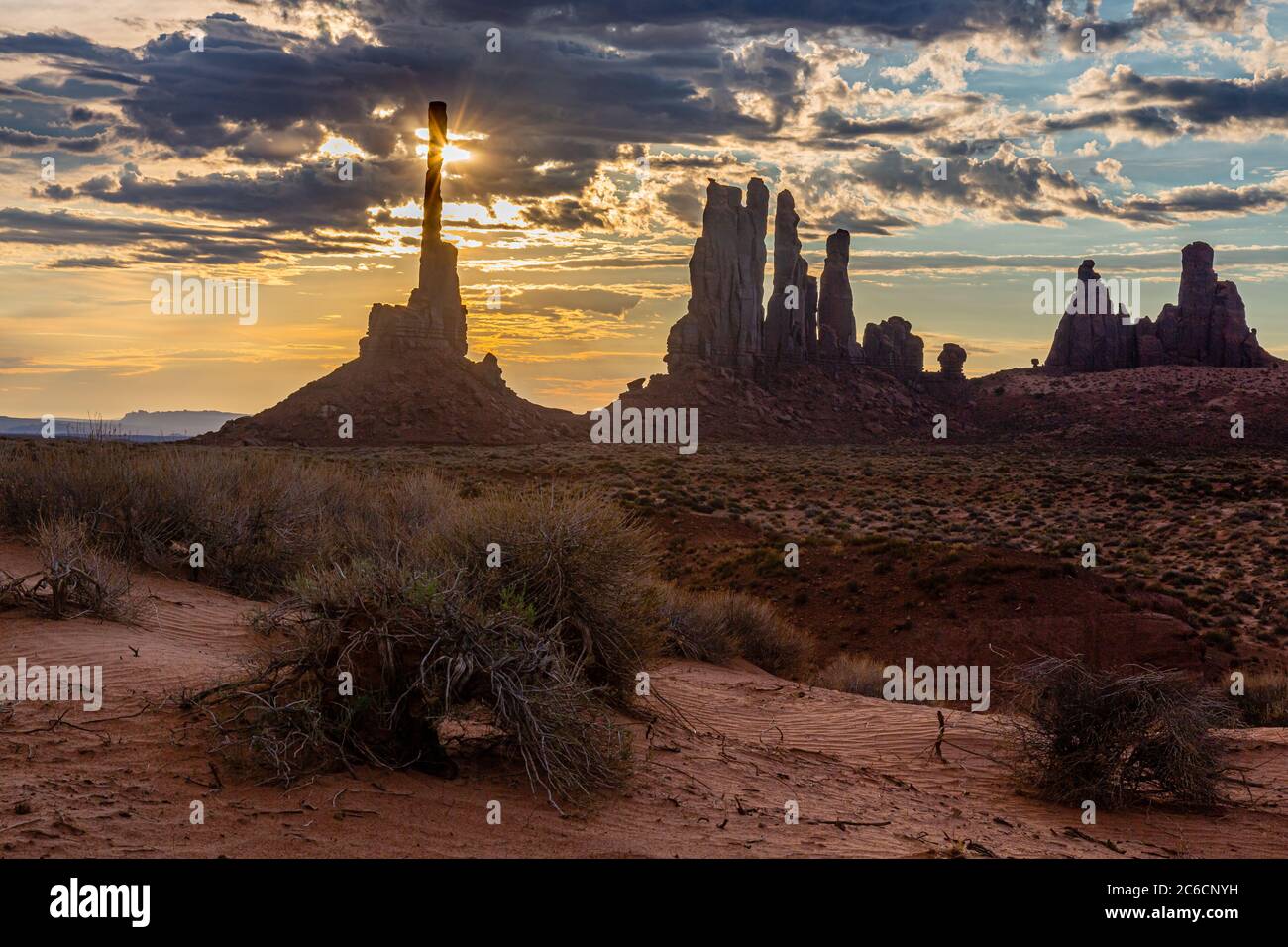 Sunburst at sunrise behind Totem Pole formation. Monument Valley Tribal ...