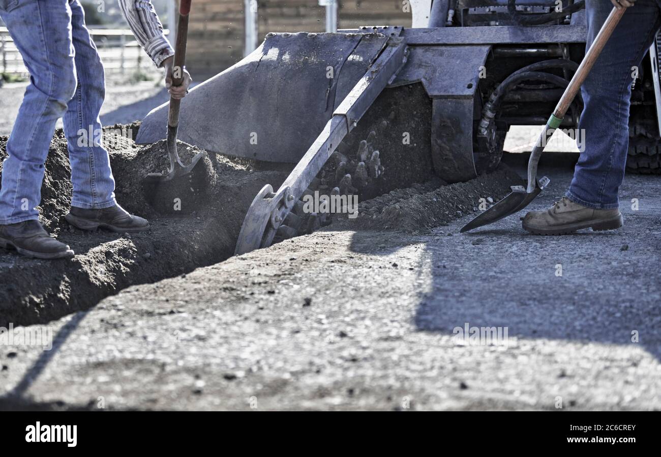 Close up of a Trencher chain in motion digging a trench in dirt with ...