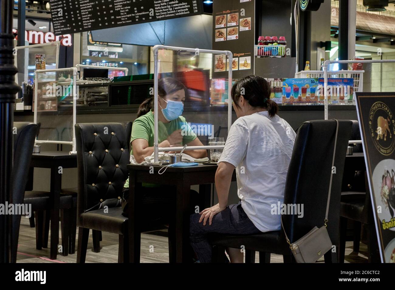 Covid 19 perspex screen separating diners in a restaurant to prevent ...