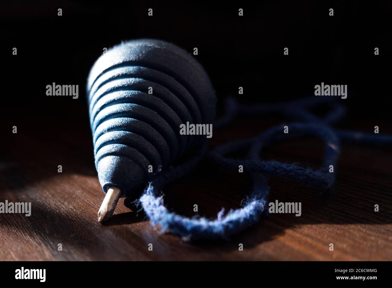 A blue color plastic spinning top isolated on wooden background top toy ...