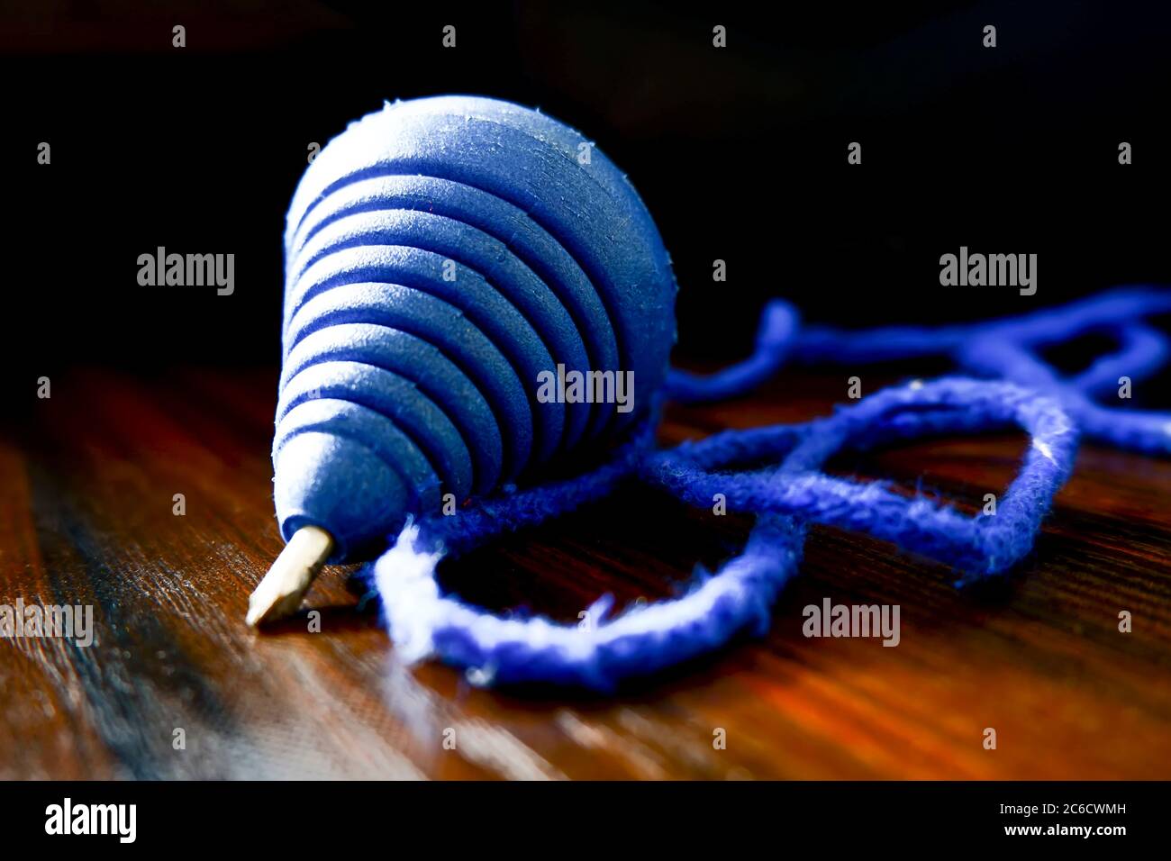 A blue color plastic spinning top isolated on wooden background top toy ...