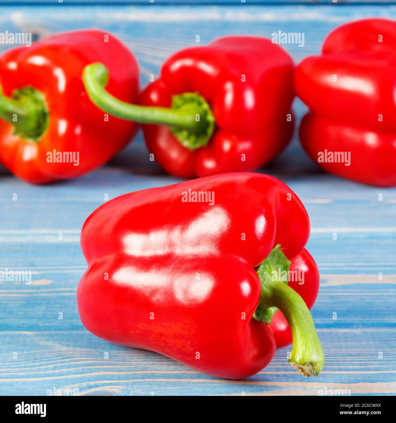 Fresh red peppers lying on blue boards, concept of healthy nutrition ...